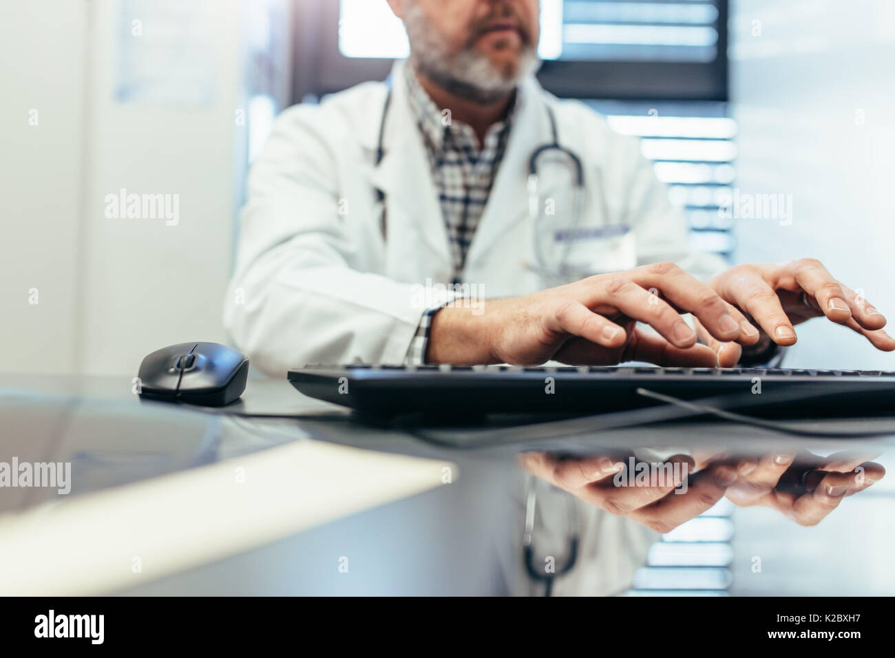 Closeup of hands of male doctor typing on computer keyboard. Medical ...