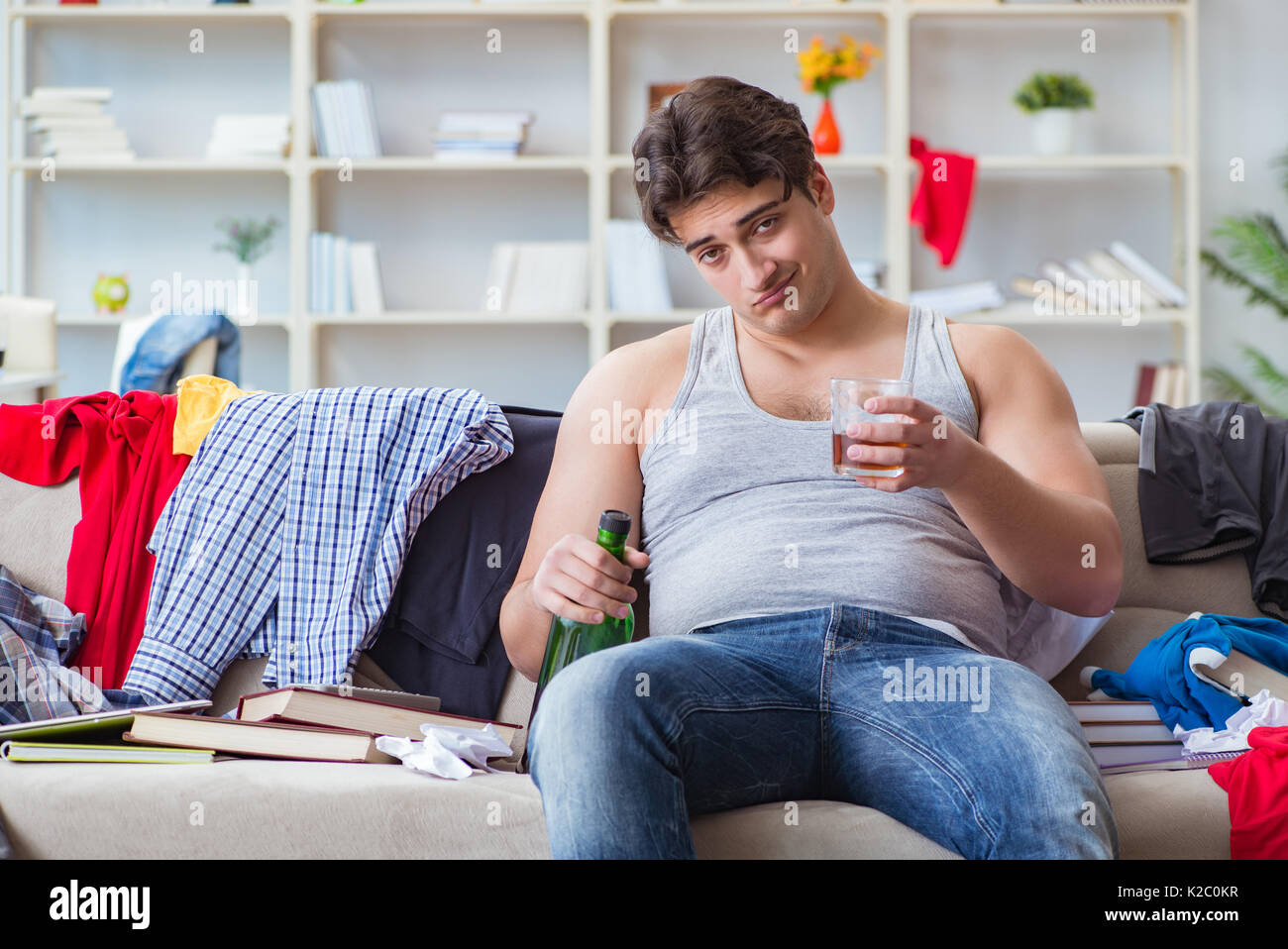 Young man student drunk drinking alcohol in a messy room Stock Photo ...