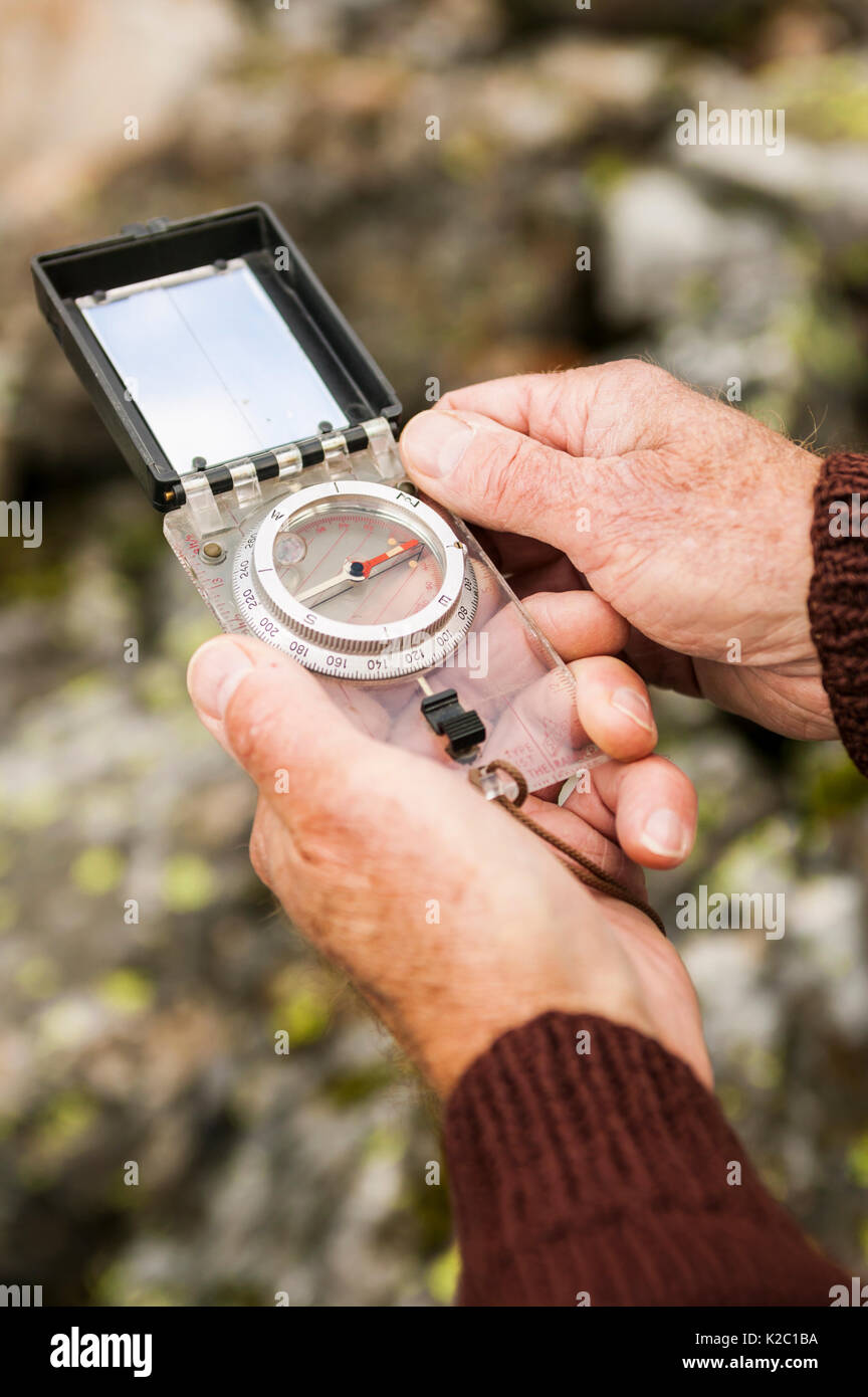 A close-up view of a mans hands operating a compass outside Stock Photo ...