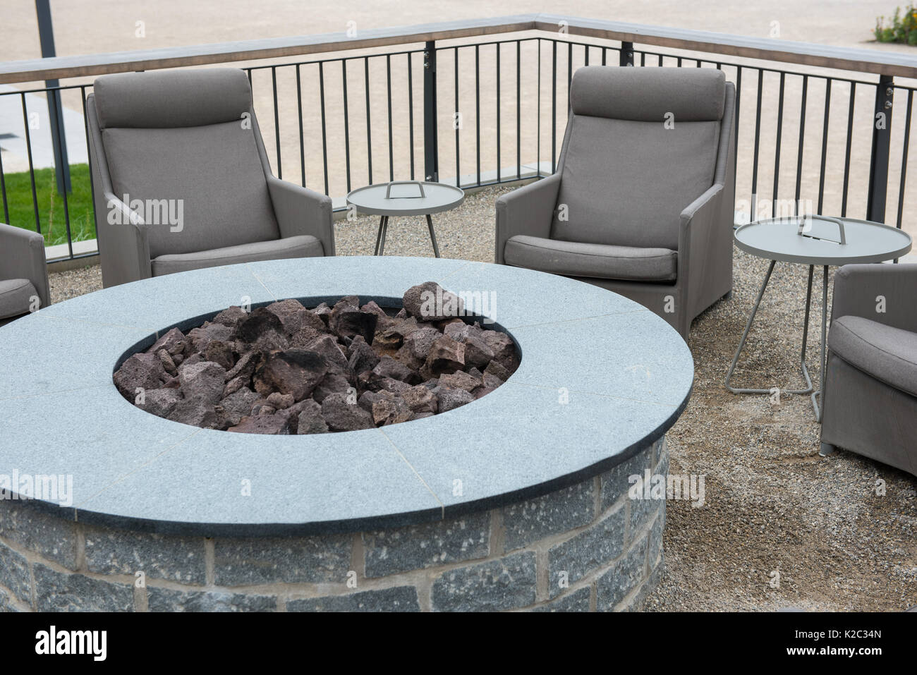 Round gas fire station with basalt stones with tables and lounges Stock ...
