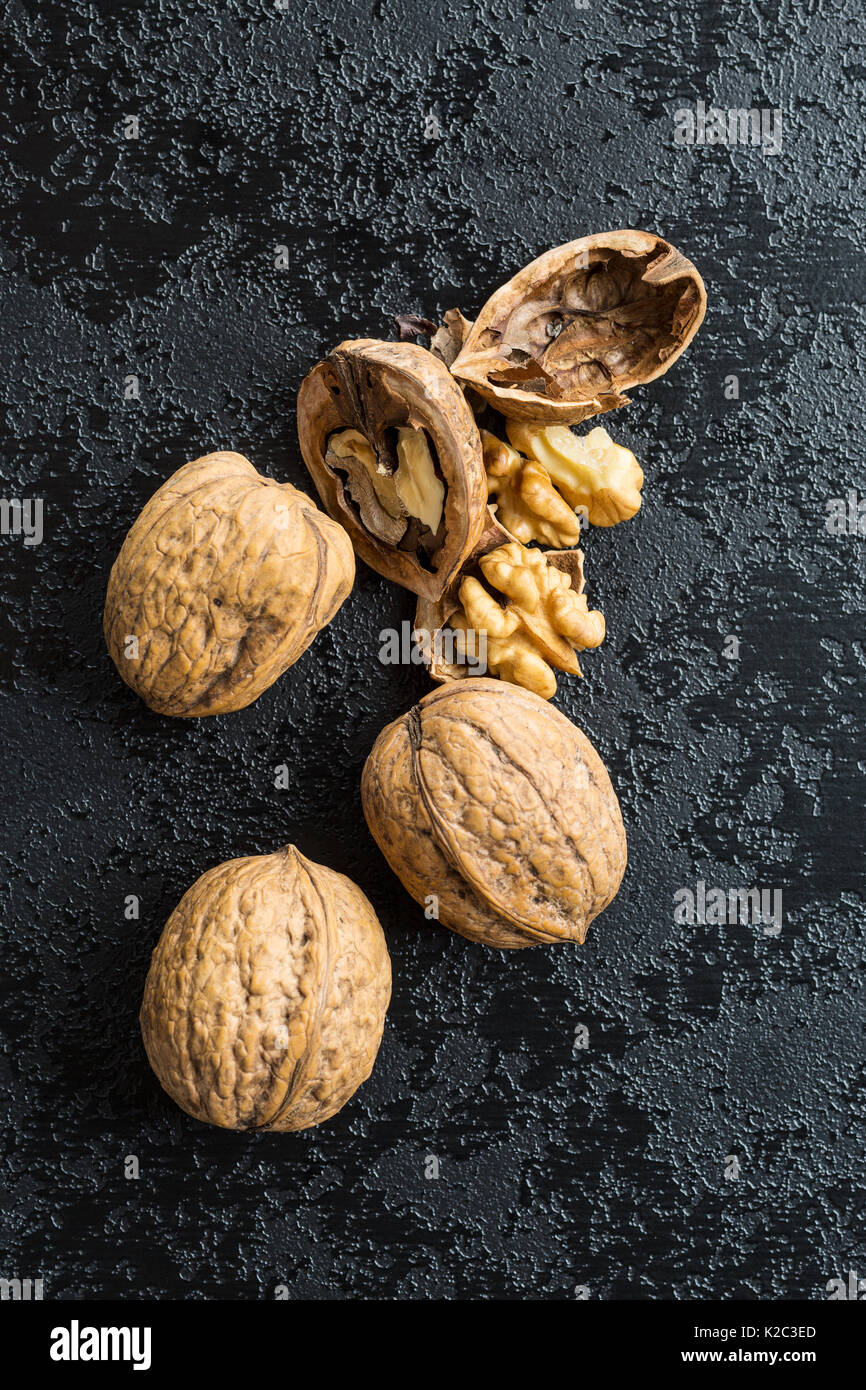 Cracked dried walnuts on black table Stock Photo - Alamy