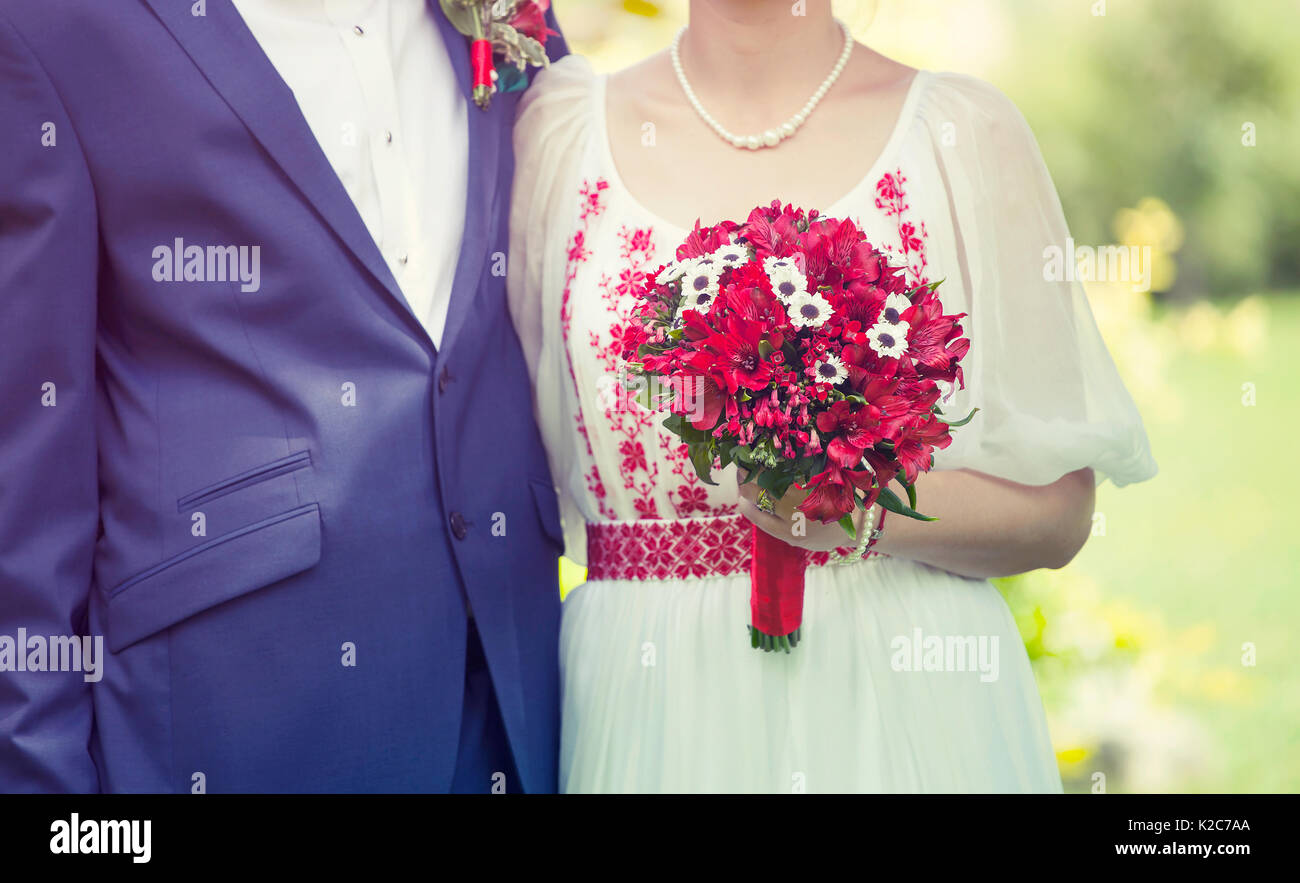 Groom and bride with red bouquet on their wedding day Stock Photo - Alamy