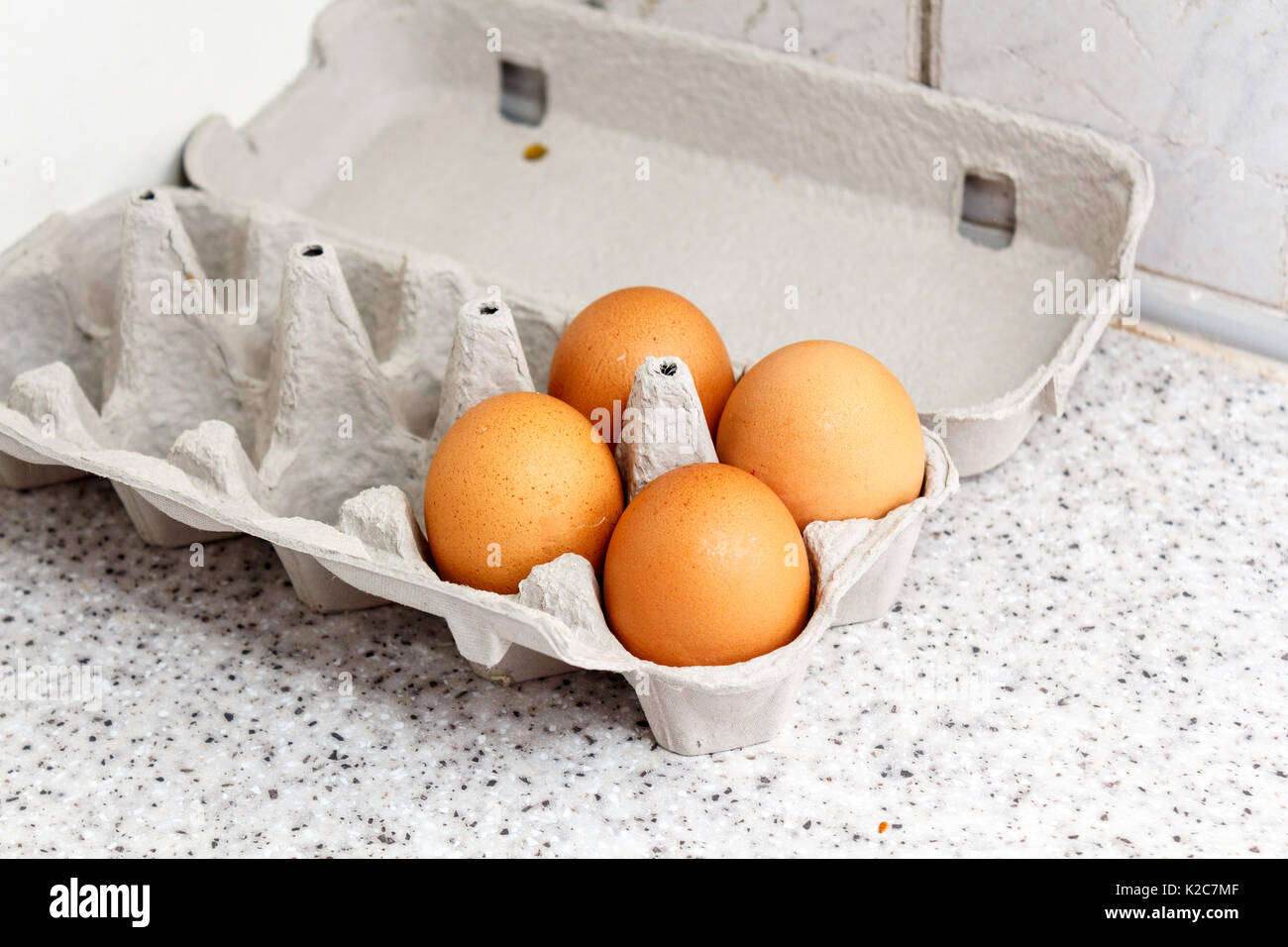 Cardboard egg box with four brown eggs Stock Photo - Alamy