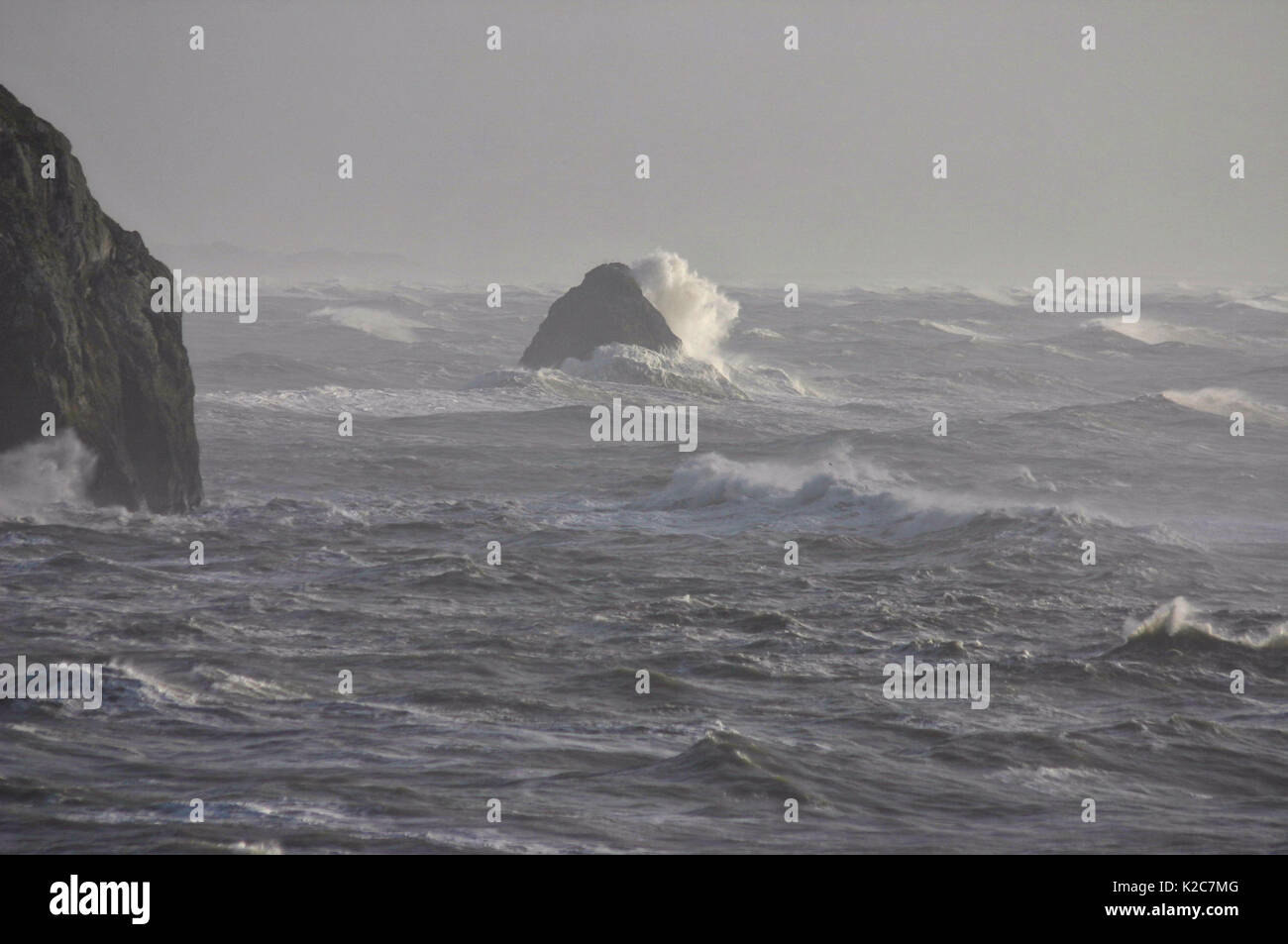 Sea stack rock formations line the shore of Trinidad Harbor on a hazy ...
