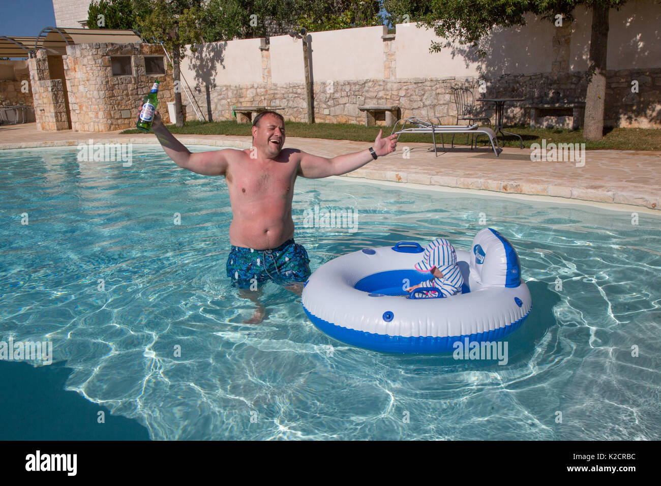 A drunk father on holiday with his toddler in a swimming pool Stock ...