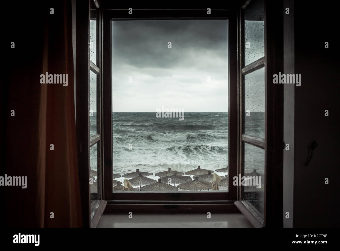 Dramatic sea view from opened window with big stormy waves and dramatic ...