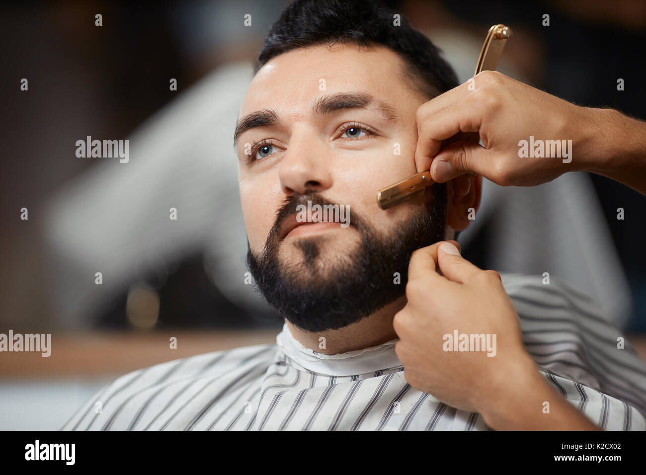 Smiling man who visiting barbershop, when barber cutting bread Stock ...