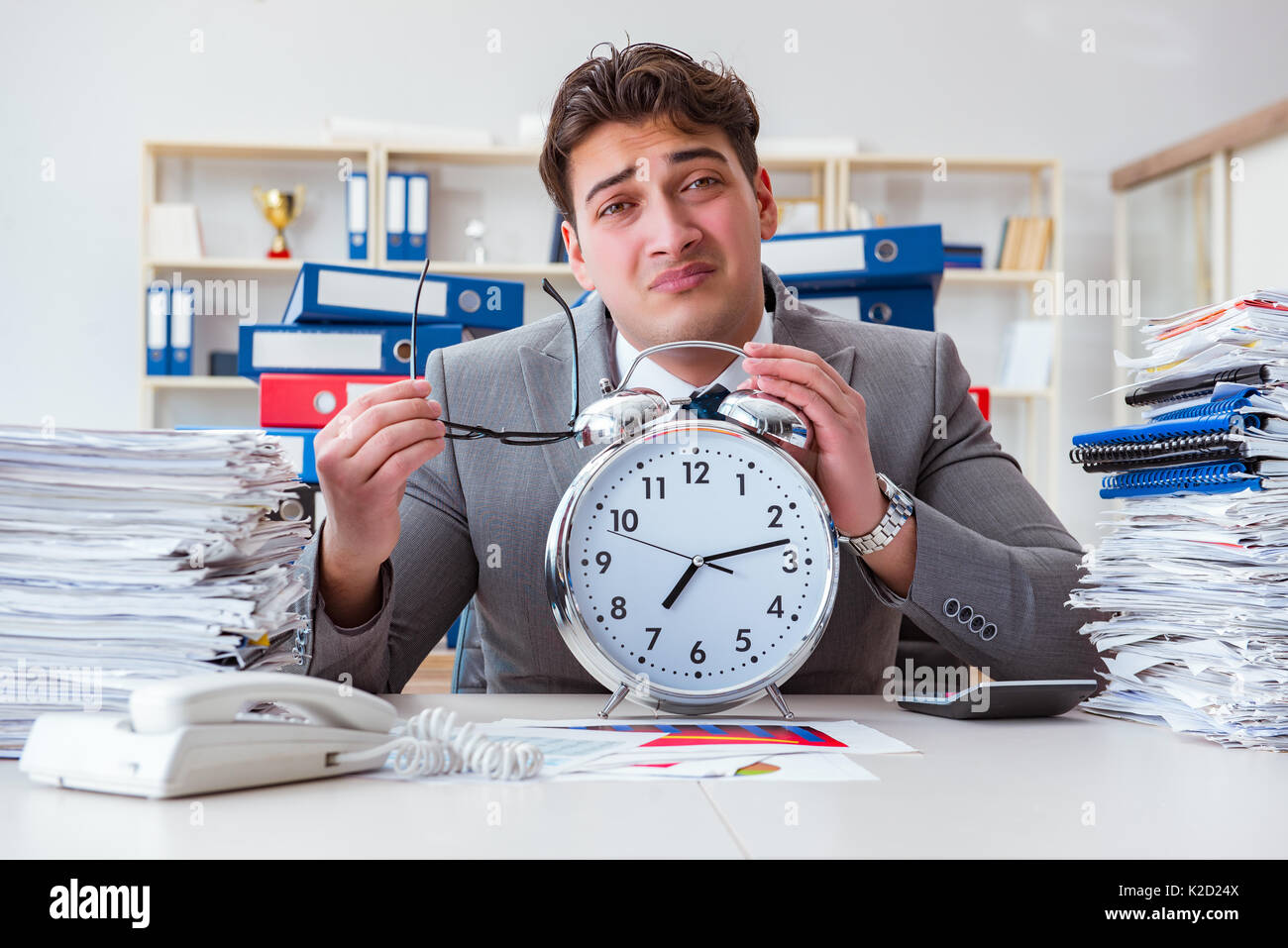 Businessman missing deadlines due to excessive work Stock Photo - Alamy