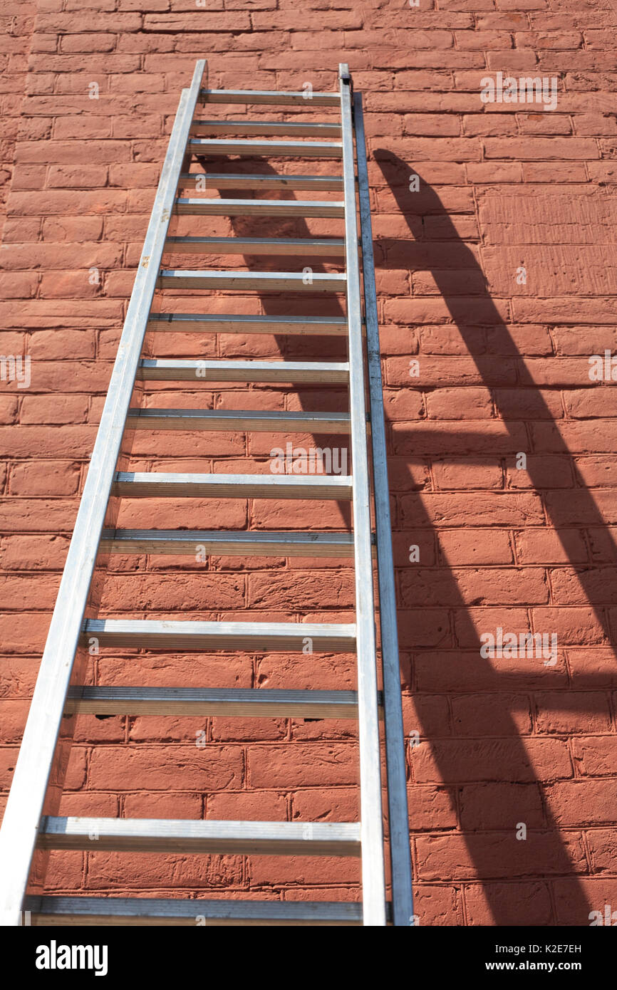 Metal ladder against red brick wall Stock Photo - Alamy