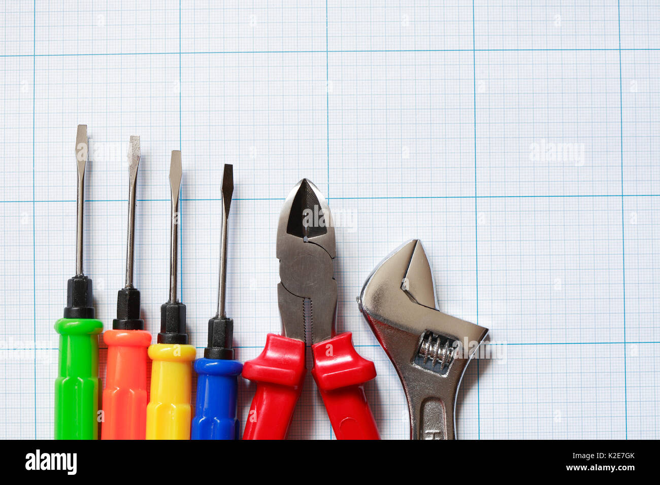 Set of work tools lying on blue graph paper surface Stock Photo - Alamy