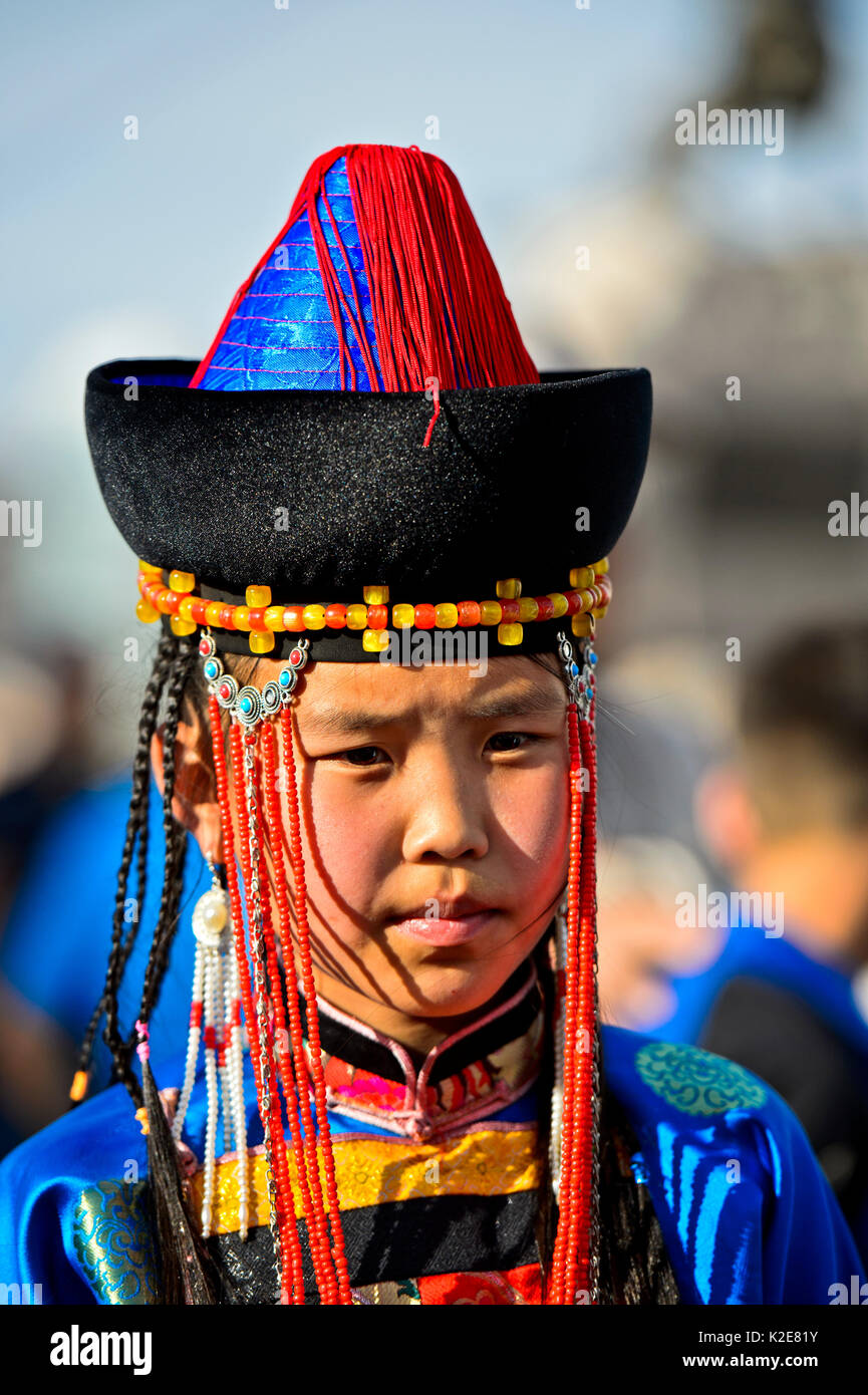 Little girl in traditional Deel clothes and hat with cone-shaped lace ...