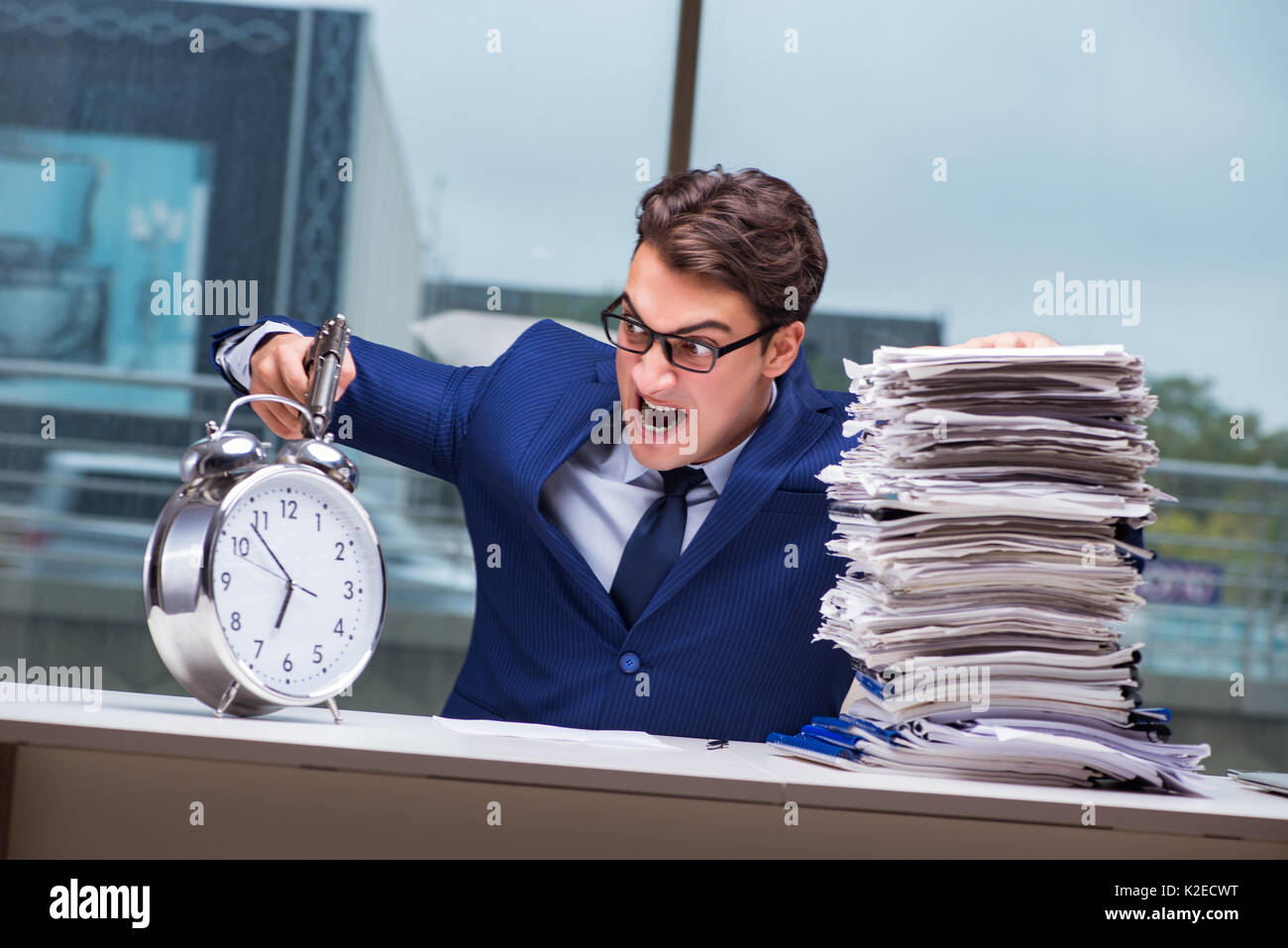 Businessman with pile stack of paper paperwork and an alarm clock ...