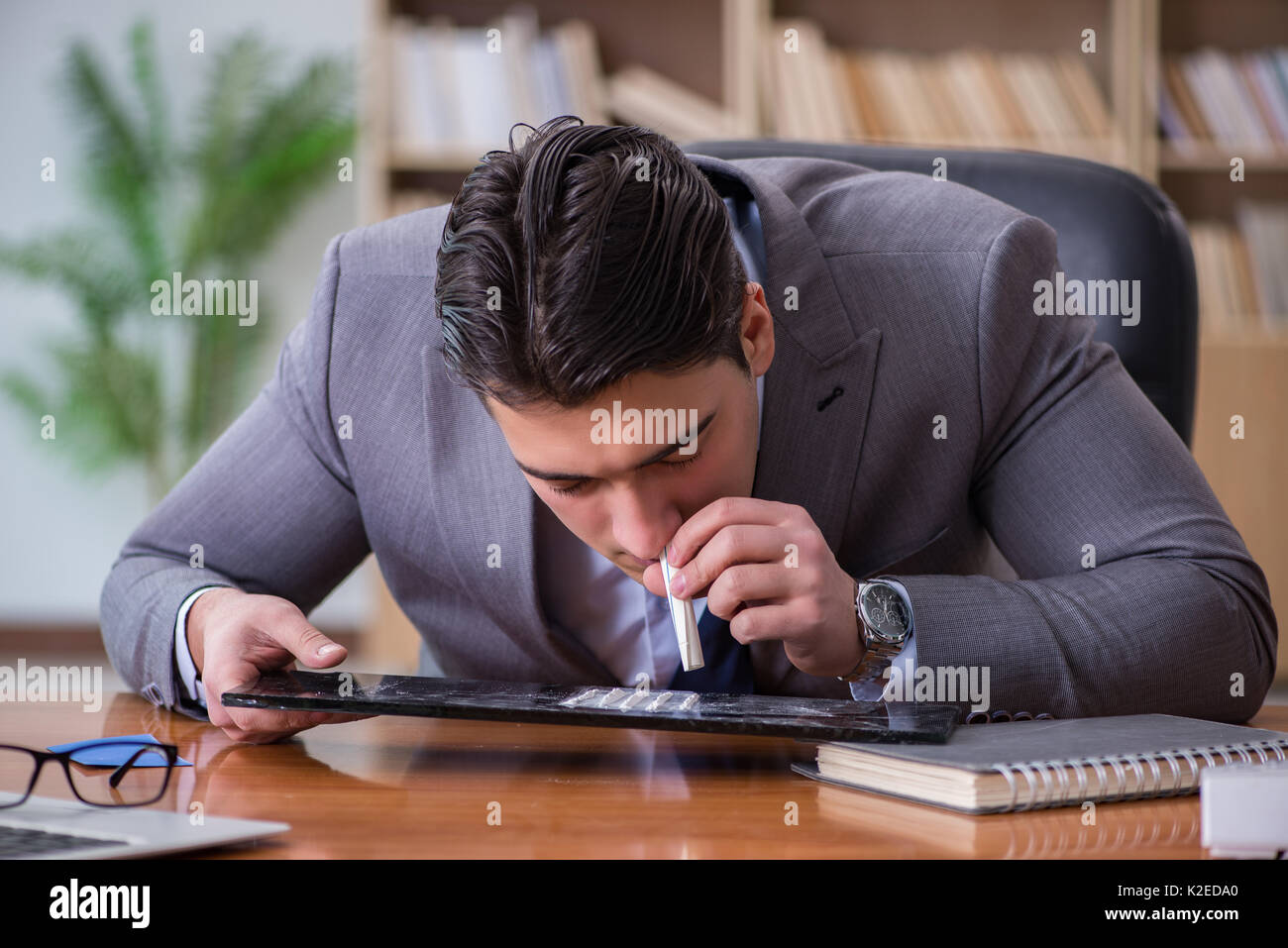 Drug addict businessman in the office Stock Photo - Alamy