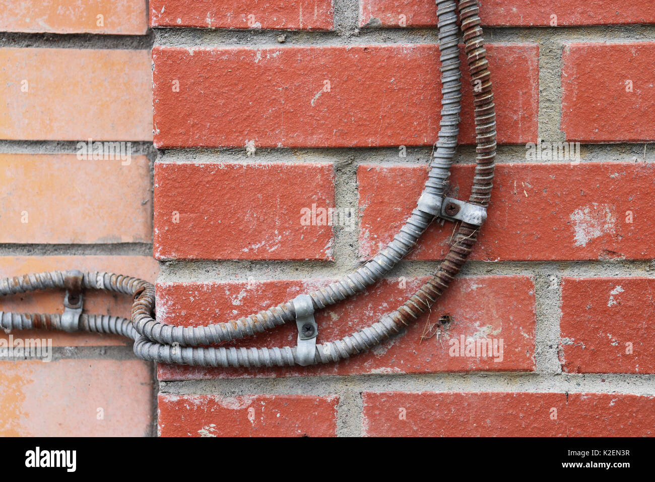 Wiring wires on red bricks building facade Stock Photo - Alamy