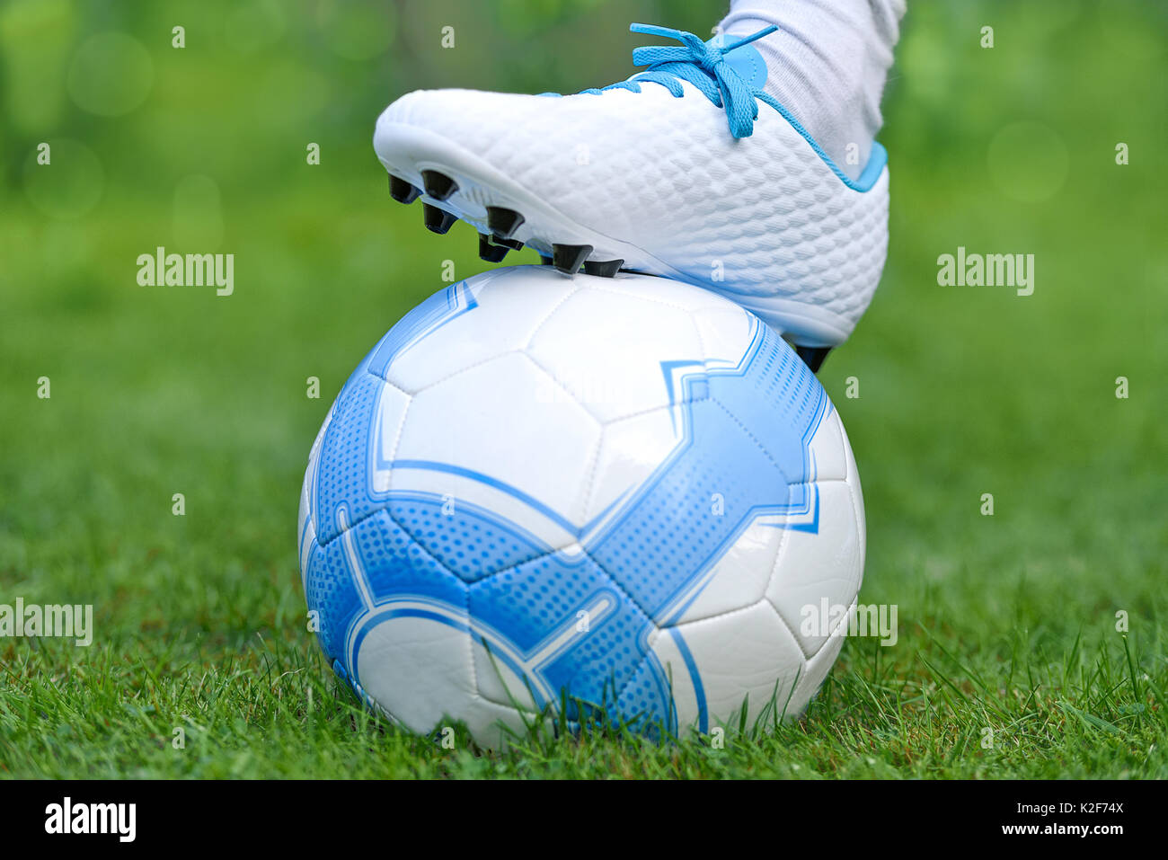 Close-up of little boy leg playing football on football pitch Stock ...