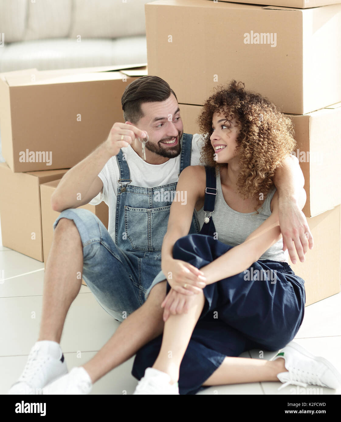 Happy new tenants sitting near cardboard boxes Stock Photo - Alamy