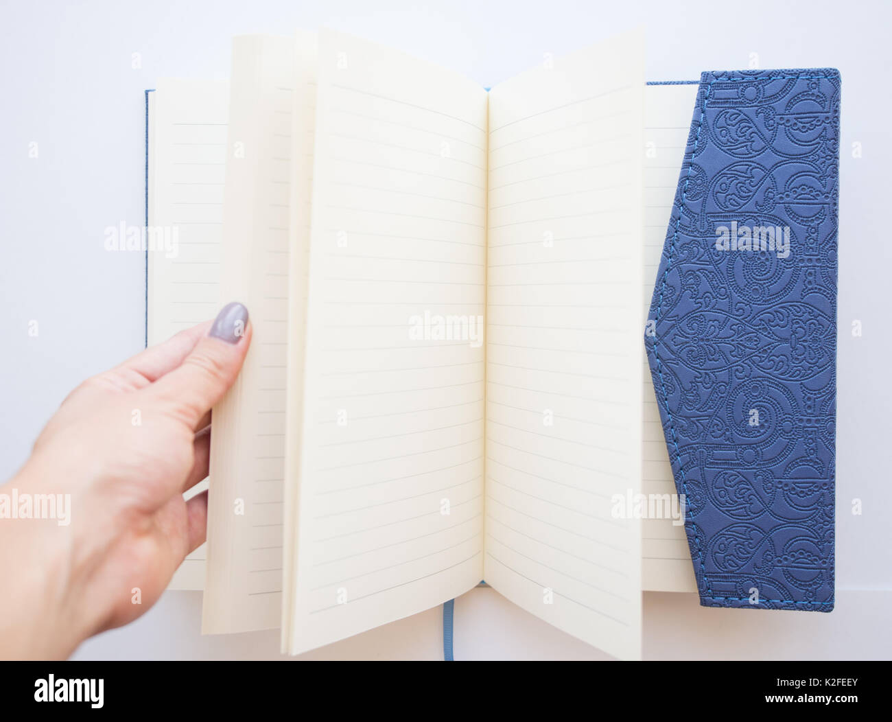 Hand flipping a diary lying on a white background Stock Photo - Alamy