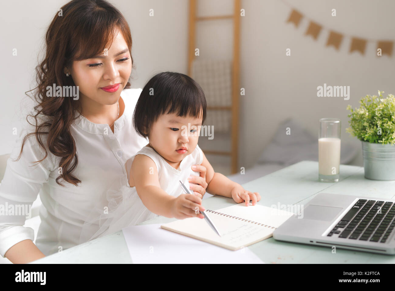 Mother and daughter are learning to write Stock Photo - Alamy