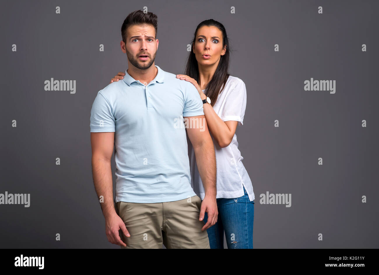 A beautiful young couple standing and feeling scared in a studio Stock ...