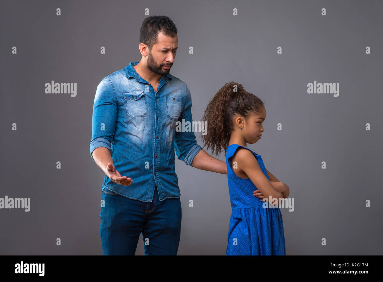 A young black man arguing with his teenage daughter who is turning her ...