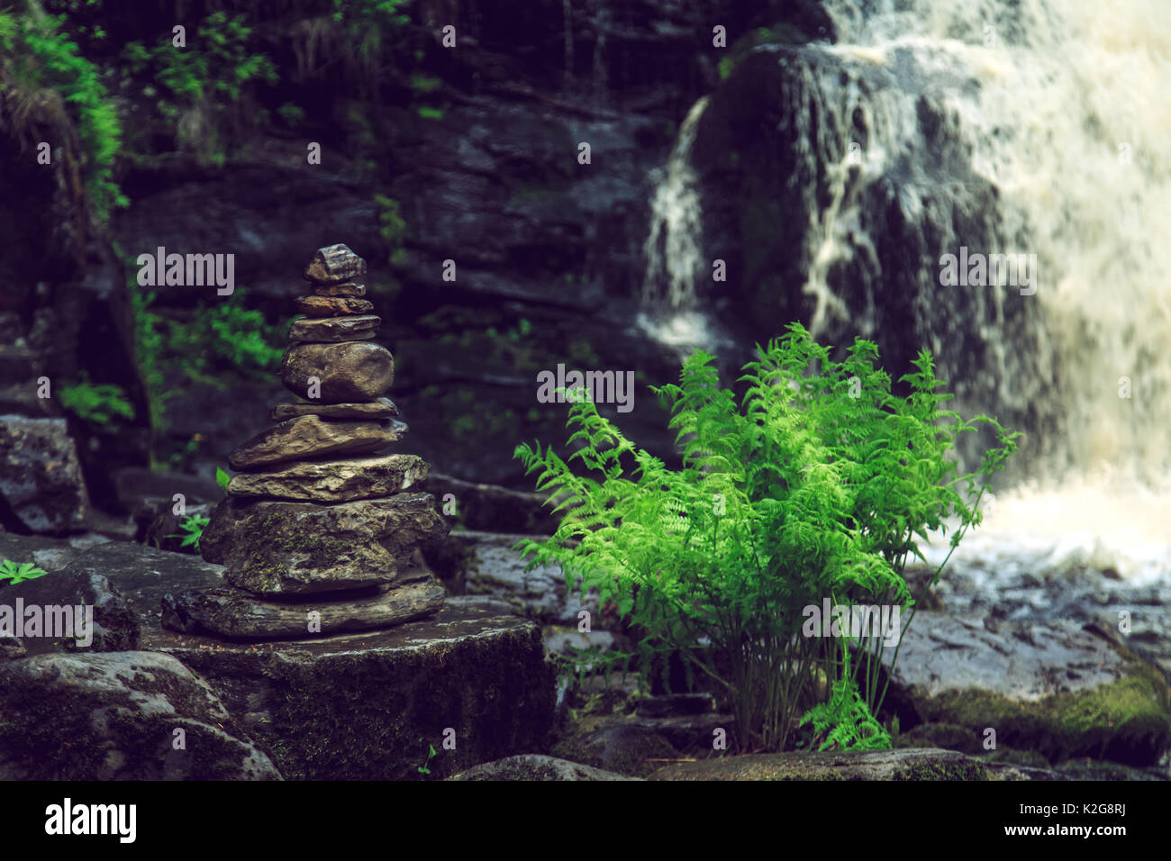 Stone pyramid near a tropical waterfall. The concept of harmony and ...