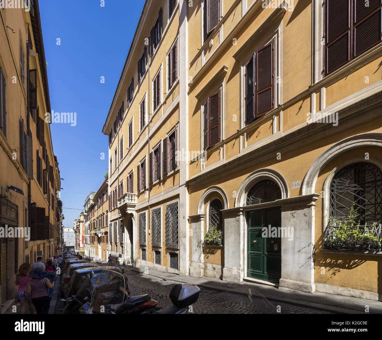 Tourists are walking around an old cozy street in Rome, Italy ...