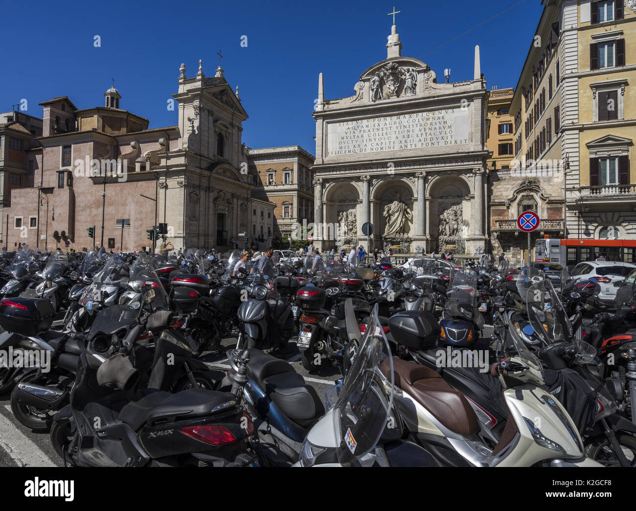 Various scooters are parked in front of a historic building in Rome ...