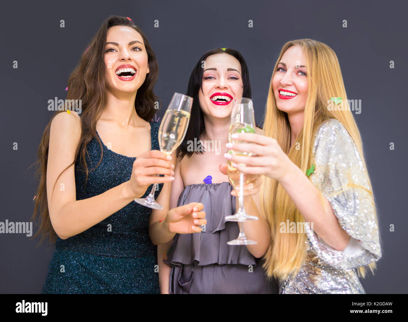 Three young smiling woman having fun an drinking champagne. Celebration ...