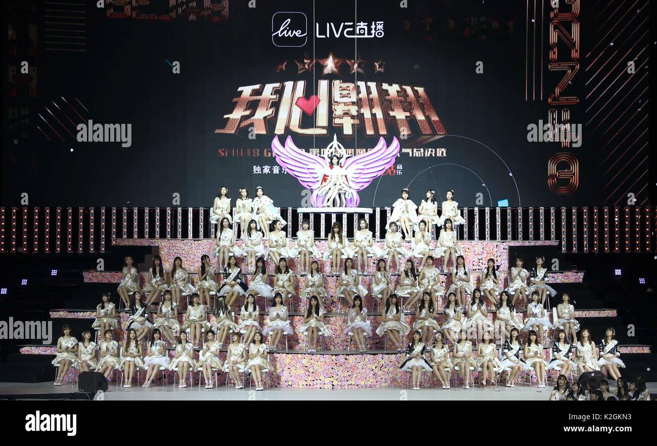 Winner Ju Jingyi, back center, of Chinese girl group SNH48 sitting on ...