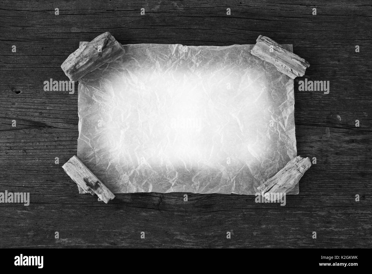 The paper crumpled leaf is pressed by stones to an old granary board ...