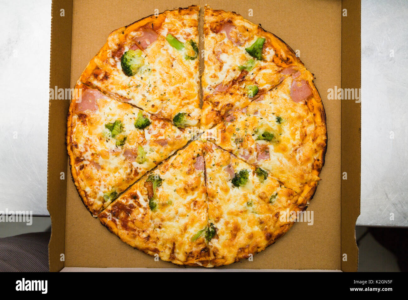 Hot freshly prepared pizza with meat, vegetables and grated cheese from ...