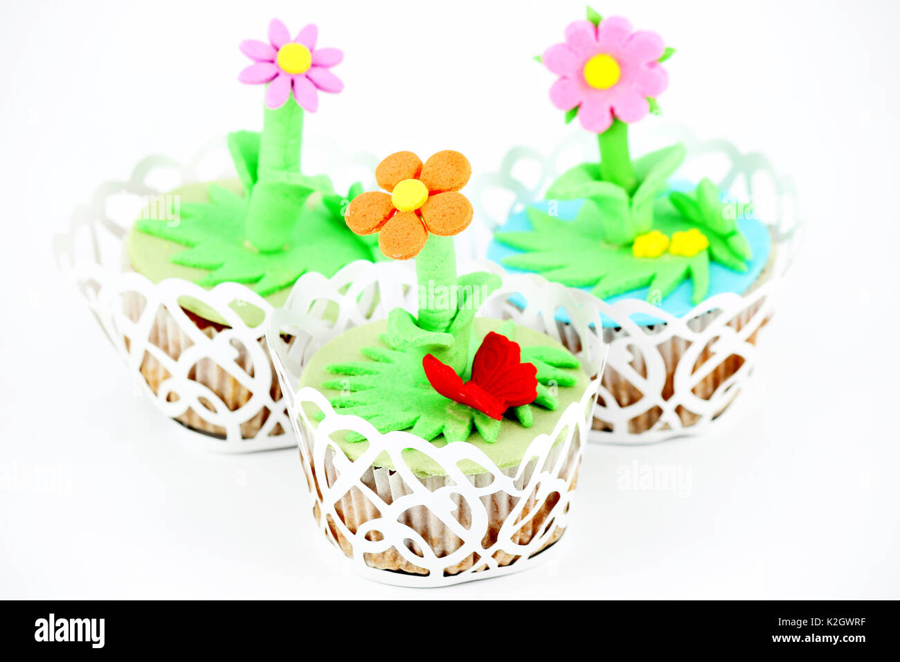 three spring flowers muffin cakes on white Stock Photo - Alamy