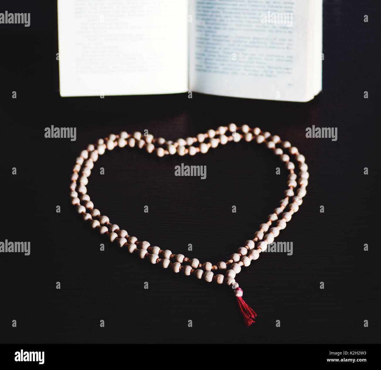 Old wooden rosary beads on a book of ceremonies. photo with copy space ...