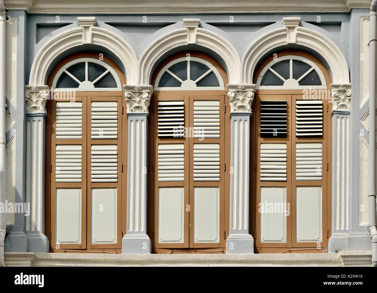 Traditional shop house exterior with brown and white wood louvered ...