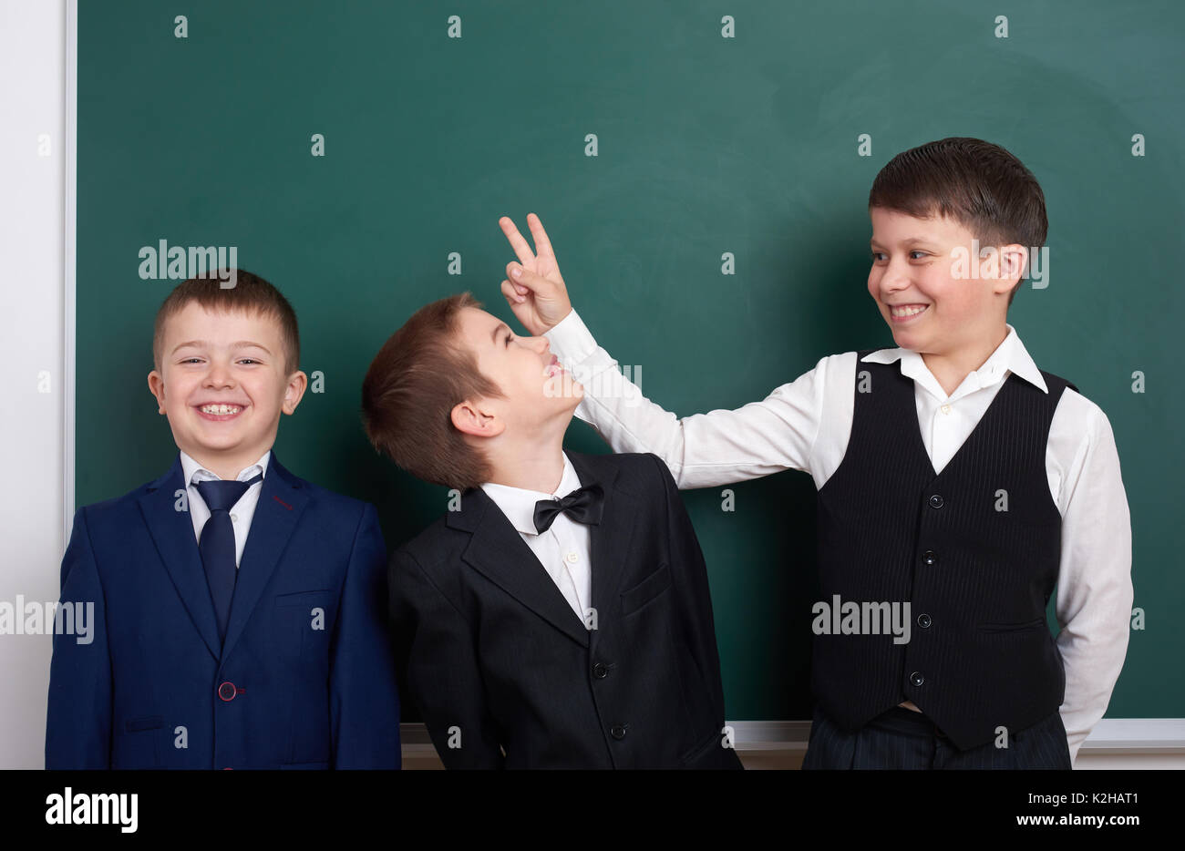 elementary school boy friends, fooling around near blank chalkboard ...