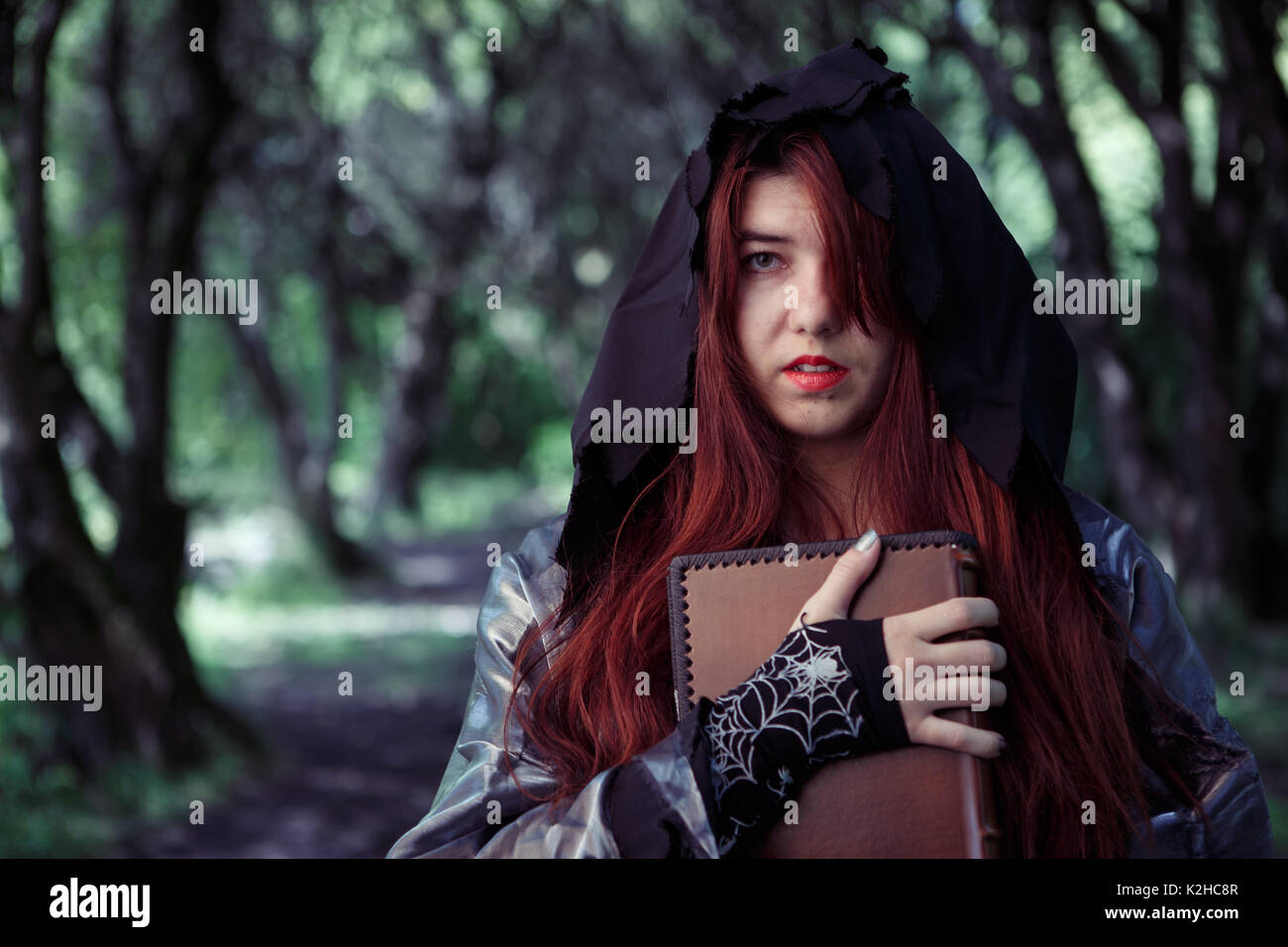 Portrait of witch with book Stock Photo - Alamy