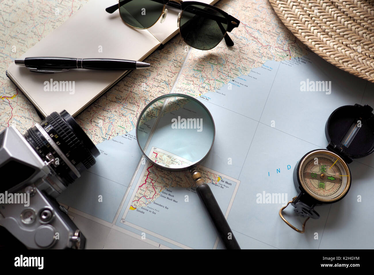 Magnifying glass and travel things on a map Stock Photo - Alamy