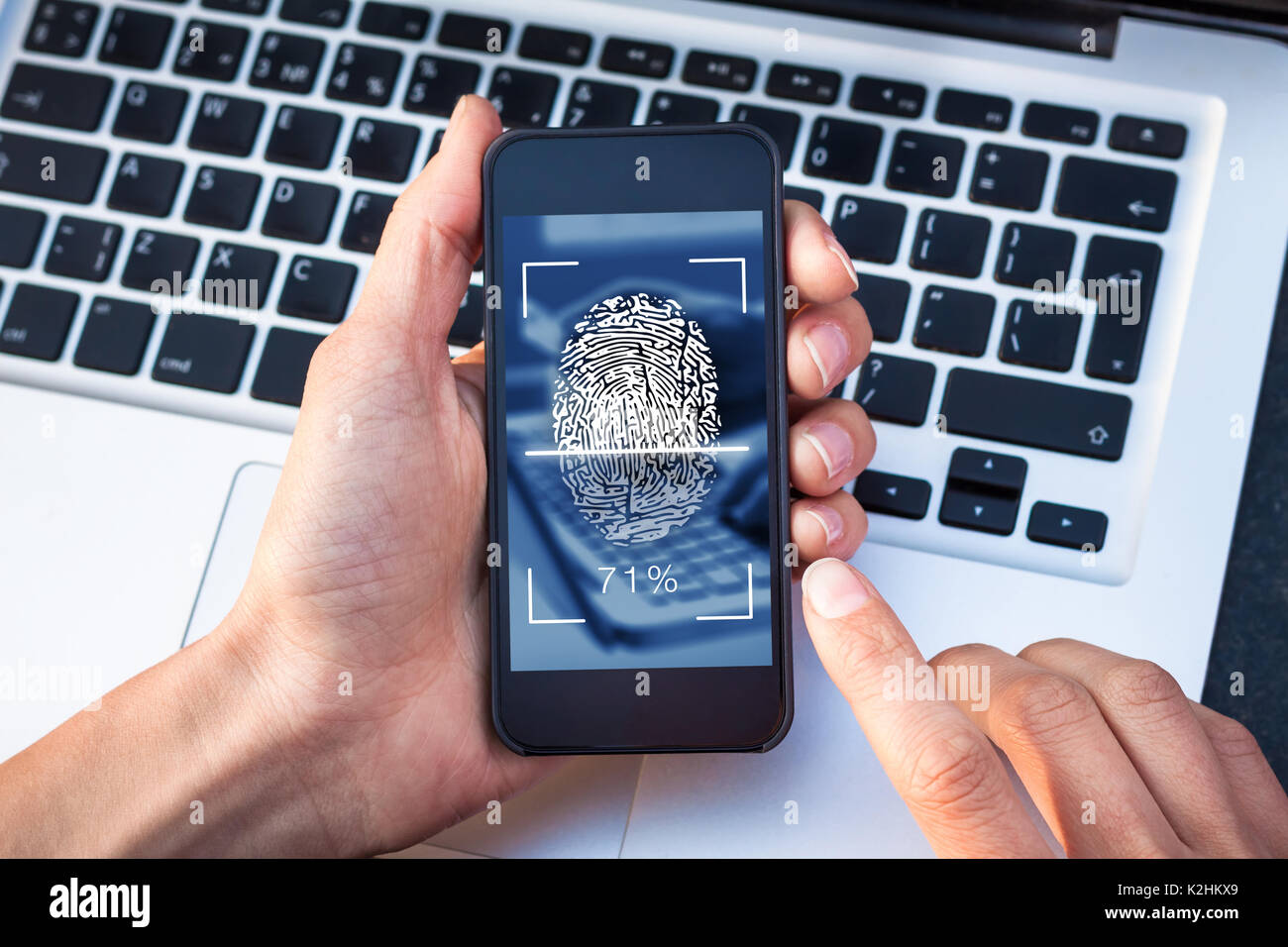 Fingerprint scanning on smartphone screen with finger touching ...