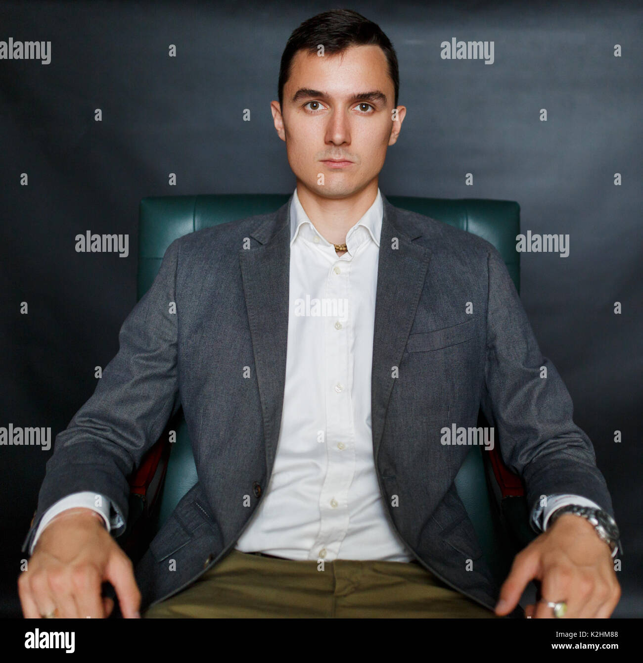 Photo of business man in suit sitting on leather chair at black empty ...