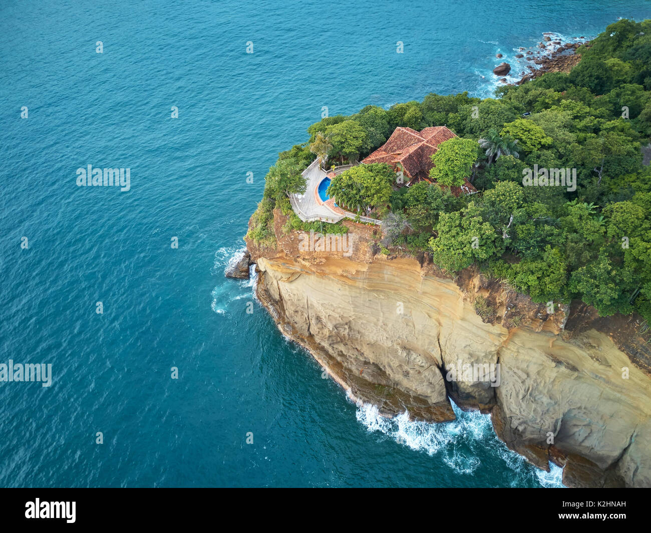 Villa in ocean big rock aerial drone view on blue sea water background ...