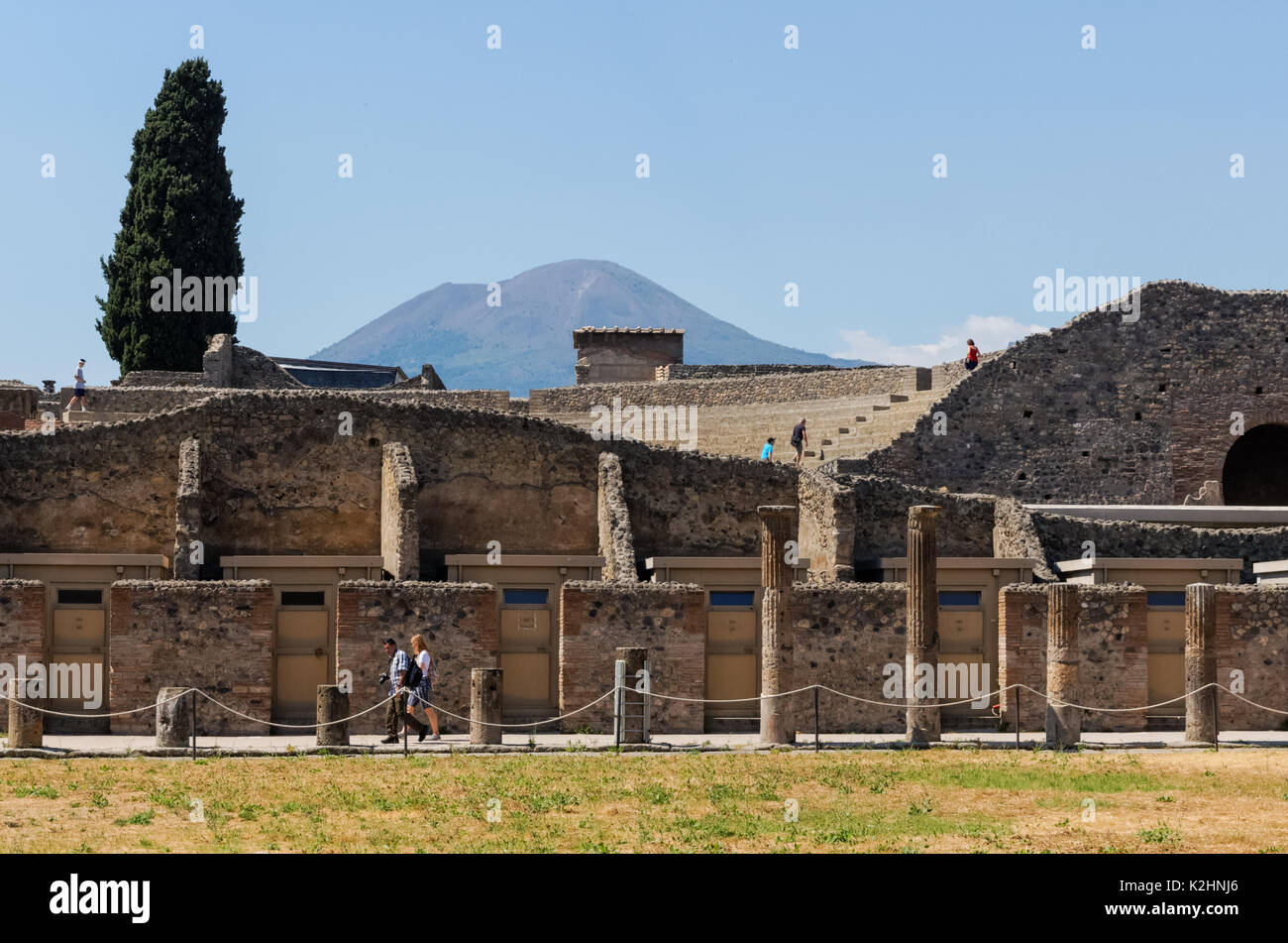 Tourists visiting Roman ruins of Pompeii with Mount Vesuvius in the ...