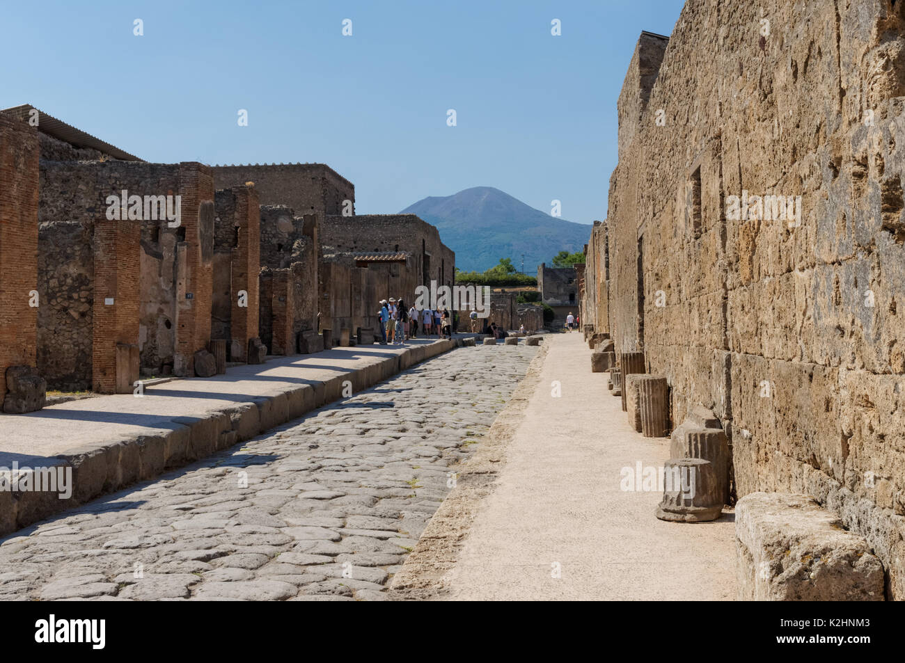 Tourists visiting Roman ruins of Pompeii with Mount Vesuvius in the ...