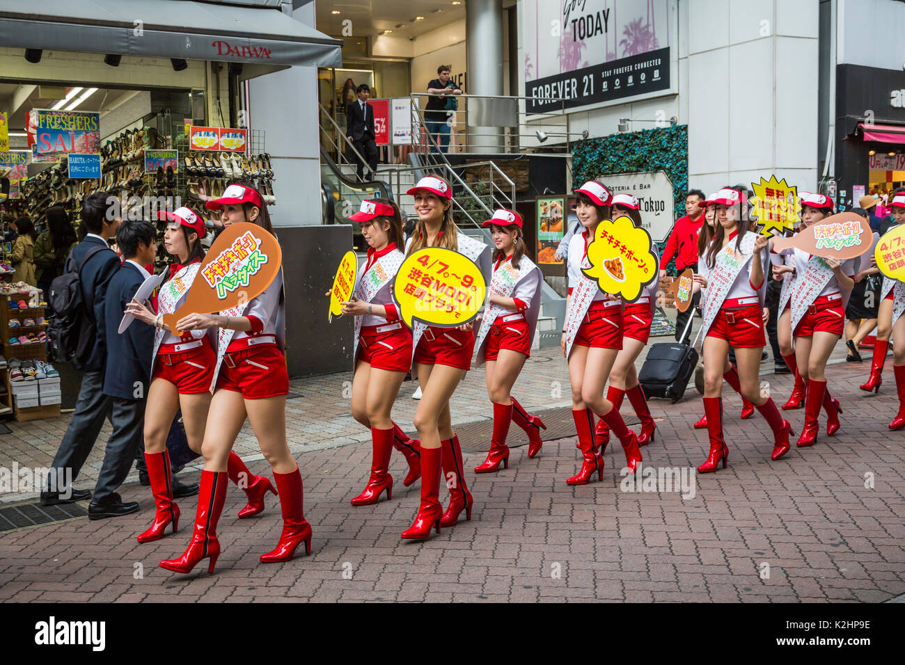A parade of young Japanese girls promoting a product on the street in ...