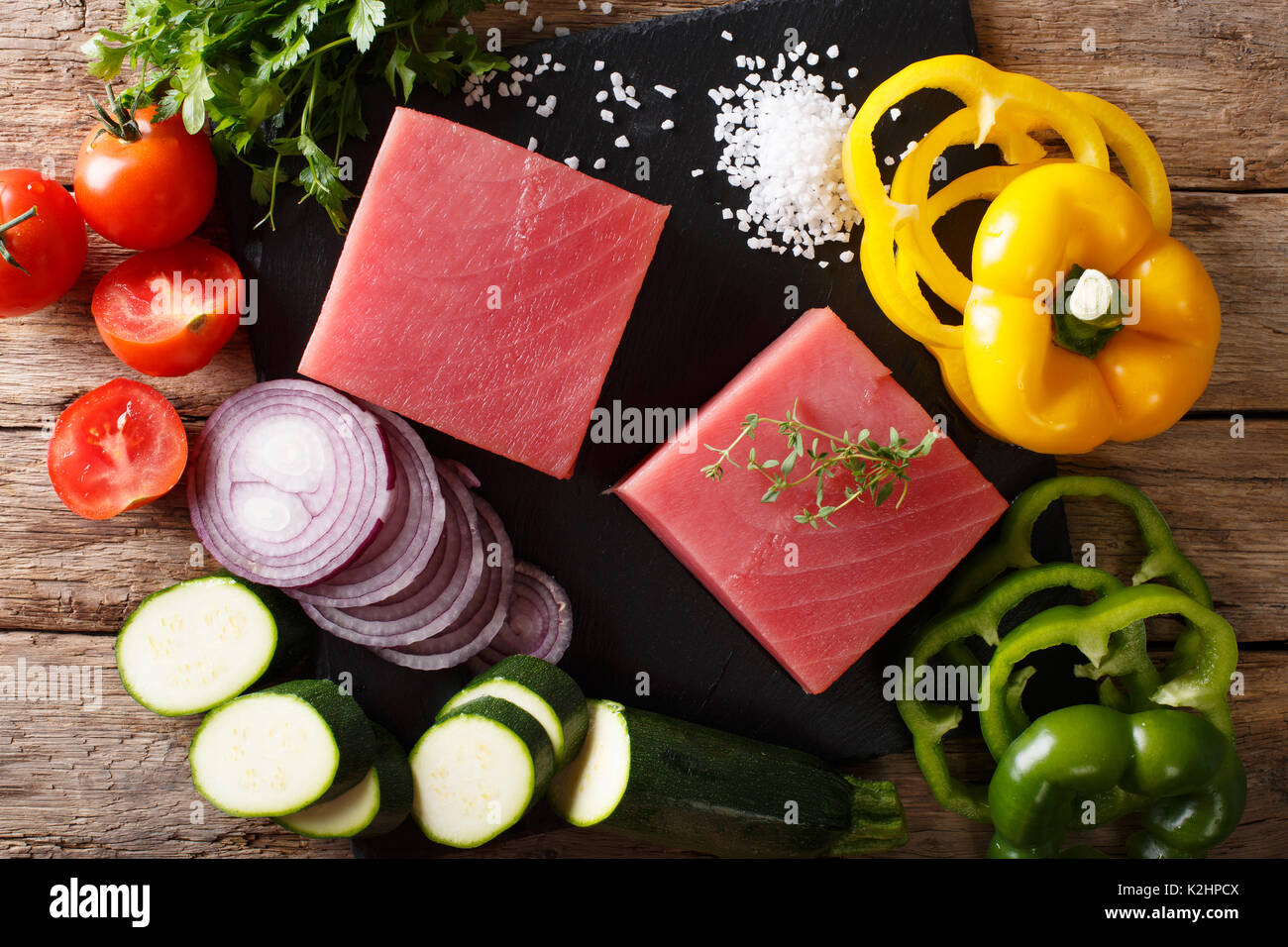 Raw fillet of tuna with pepper, onions, tomatoes, zucchini and greens ...