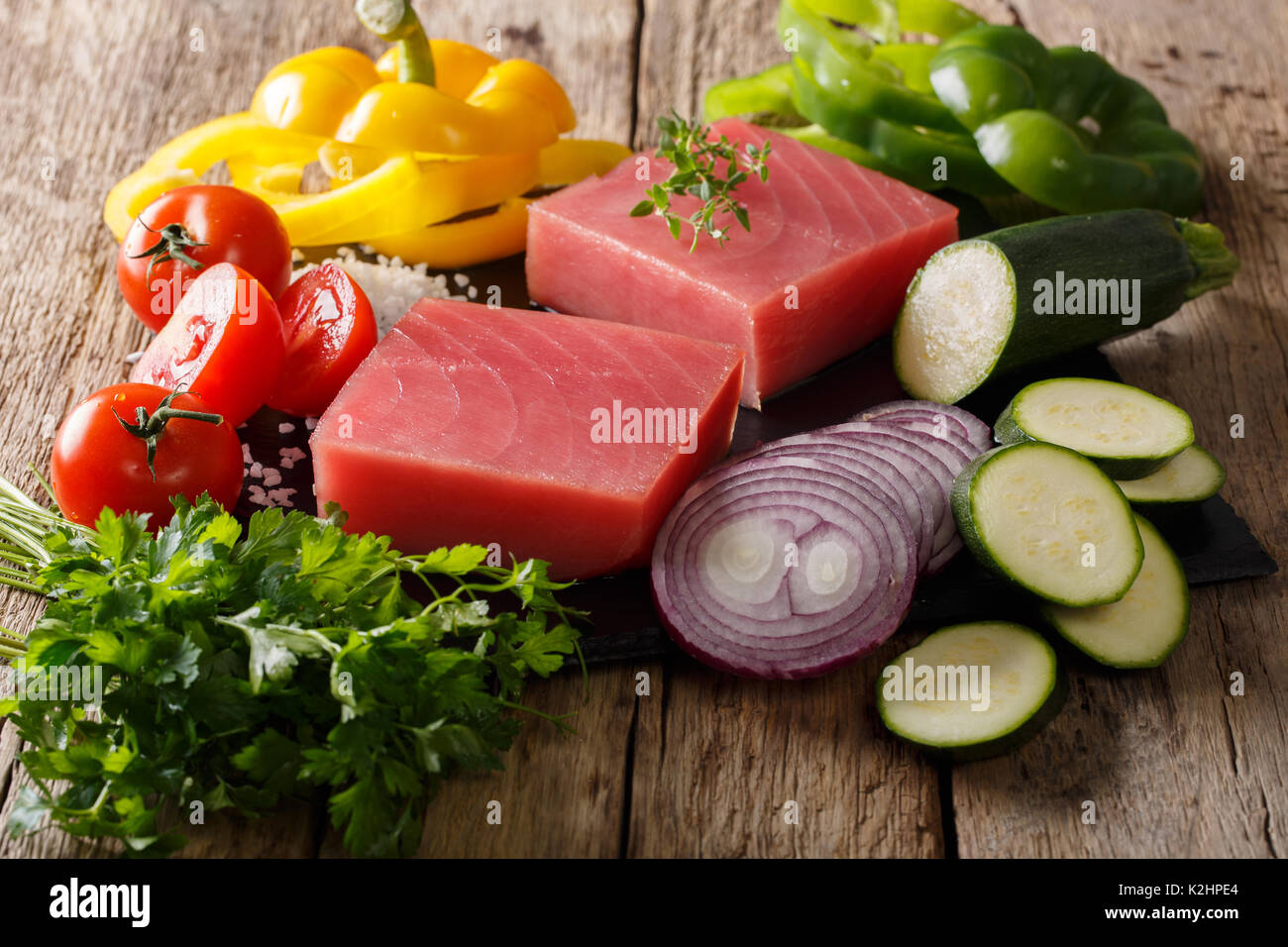 Raw fillet of tuna with pepper, onions, tomatoes, zucchini and greens ...