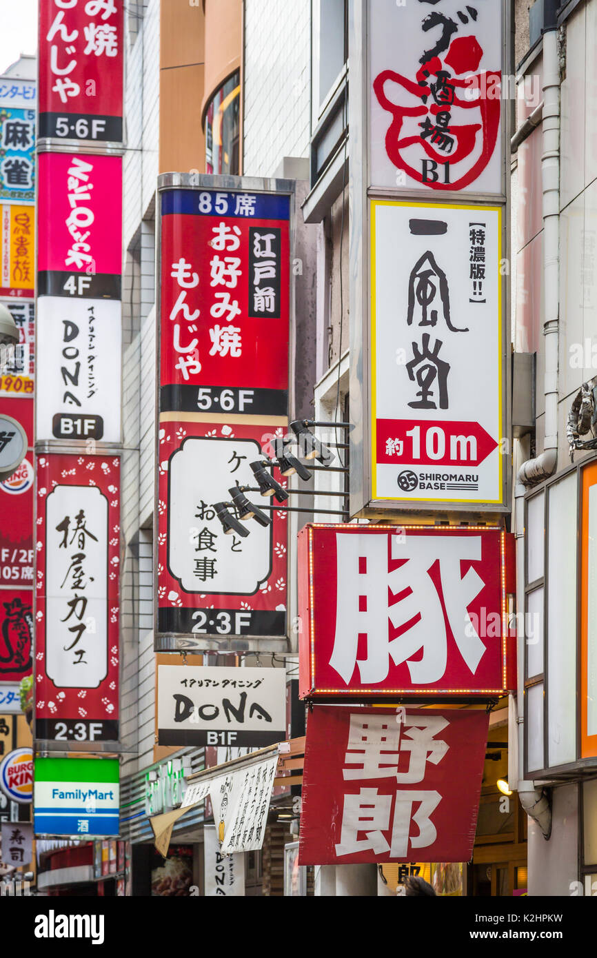 Advertising signs overhanging the streets in the Shibuya district of ...