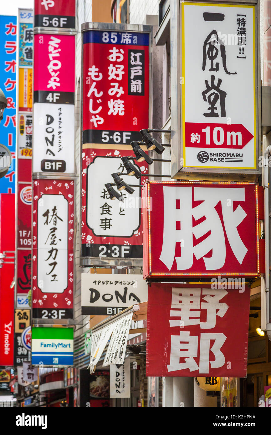 Advertising signs overhanging the streets in the Shibuya district of ...