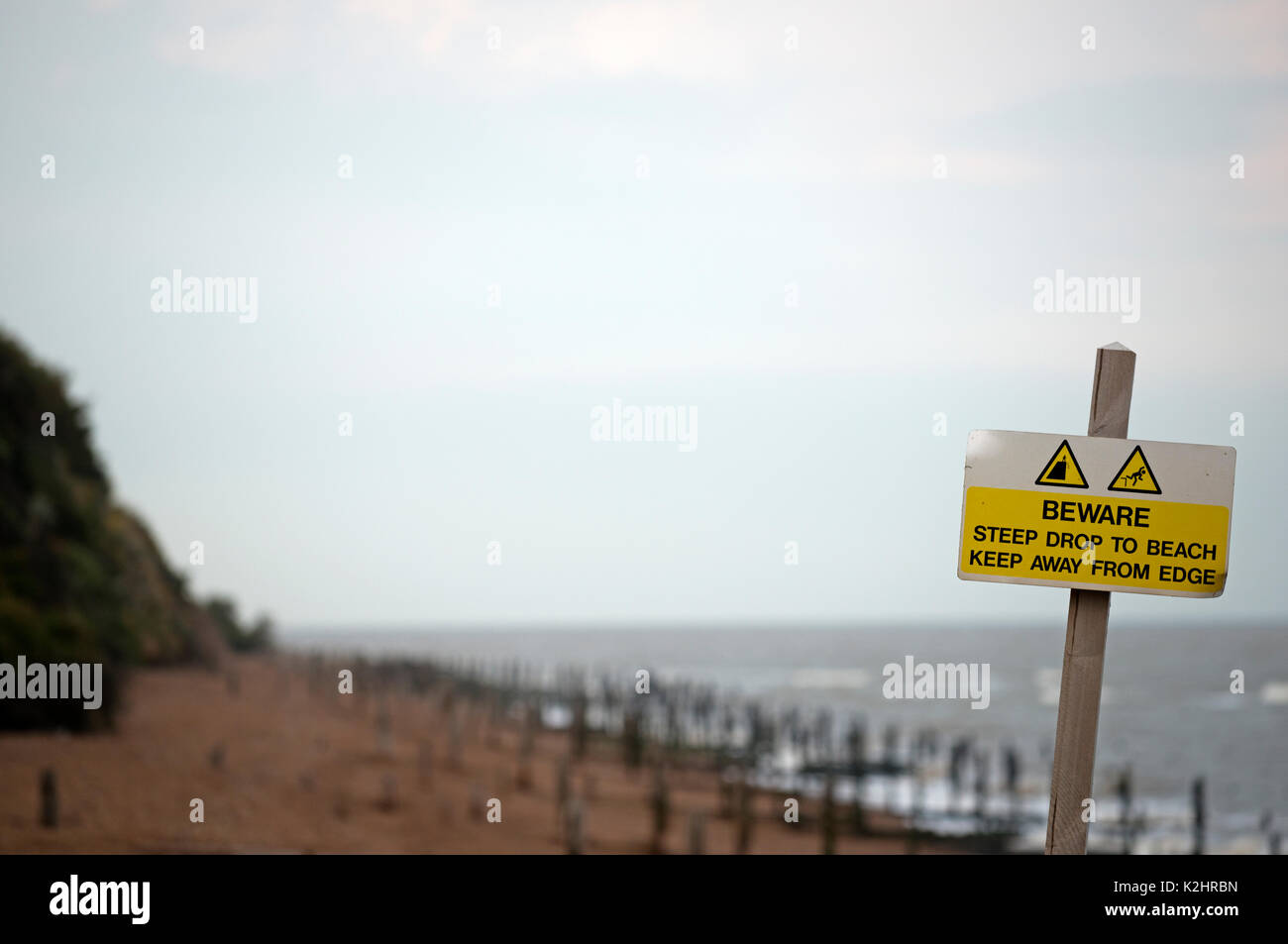 Beware steep drop to beach sign Stock Photo - Alamy