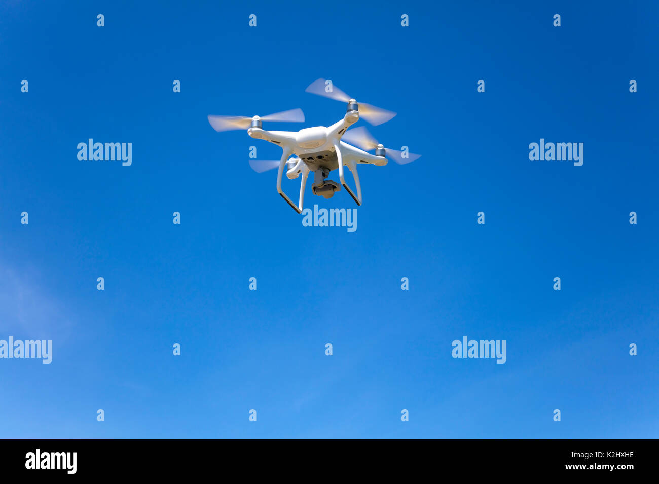 Flying drone with blue sky background Stock Photo - Alamy