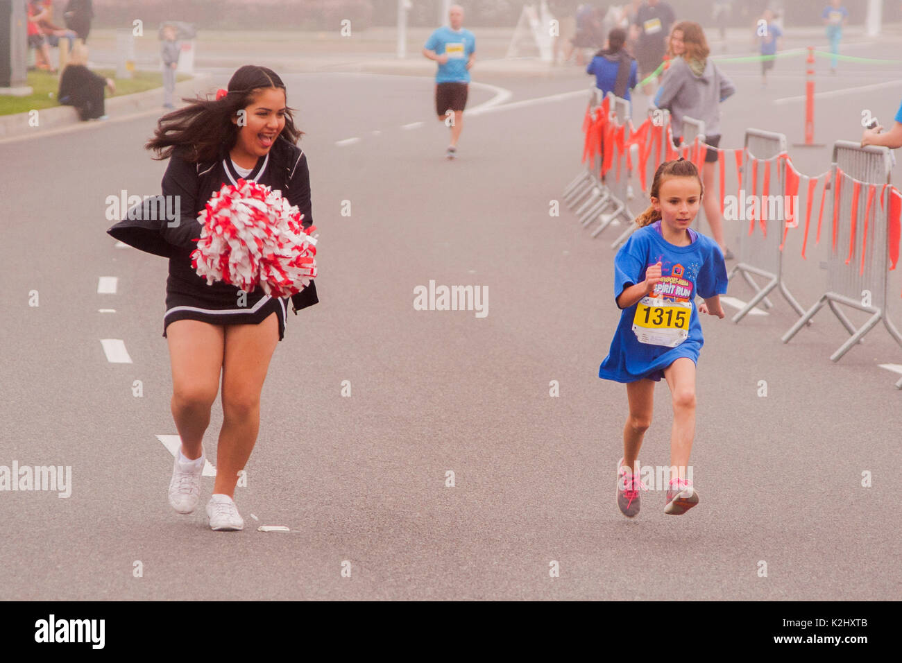Carrying her pom-poms, a teen in her cheerleader uniform encourages a ...